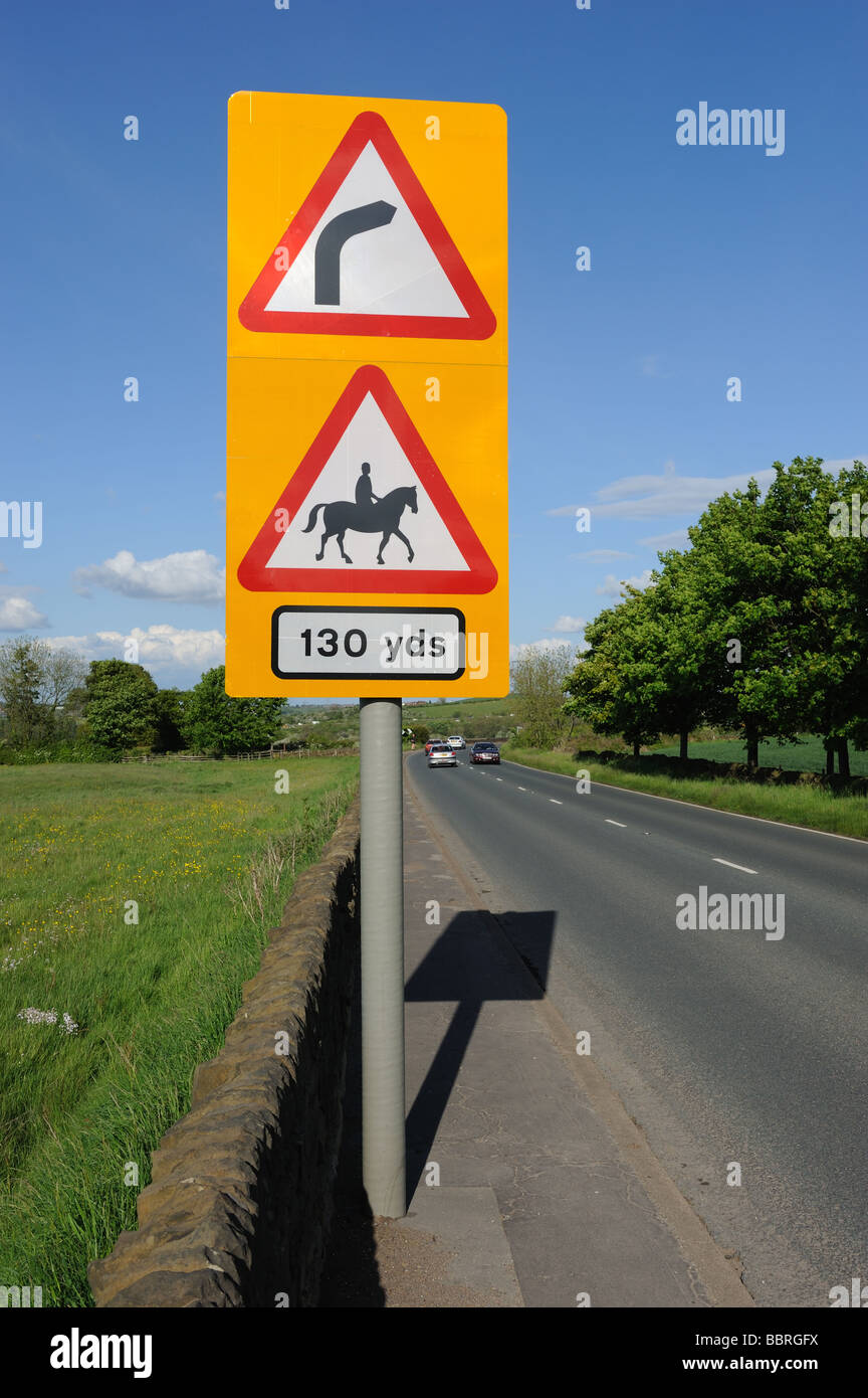 A typical country roadsign warning motorists of a sharp bend and horse ...