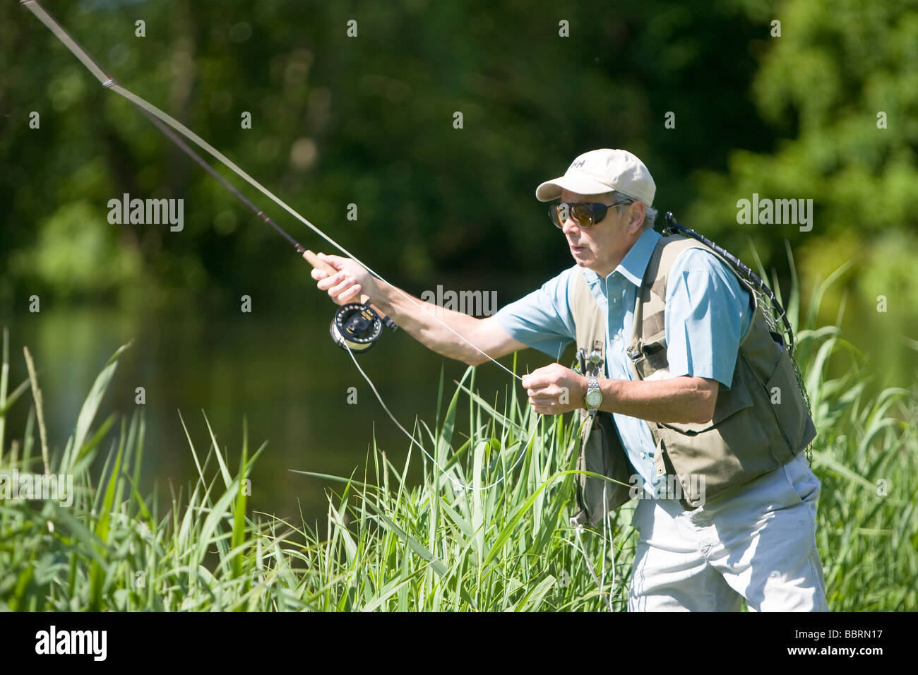 Fly fisherman casting line Stock Photo - Alamy