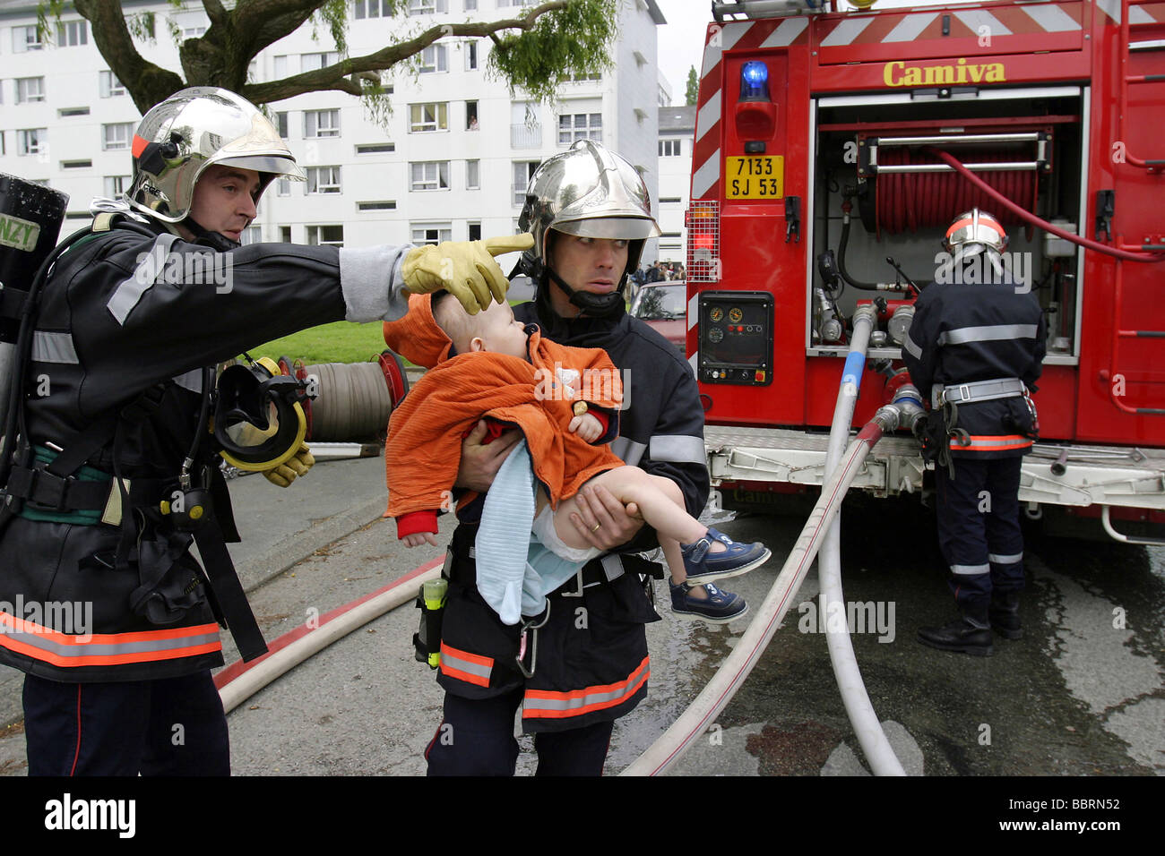FIREFIGHTERS RESCUING A CHILD FROM AN APARTMENT FIRE IN A SUBSIDIZED HOUSING BUILDING, LAVAL ...