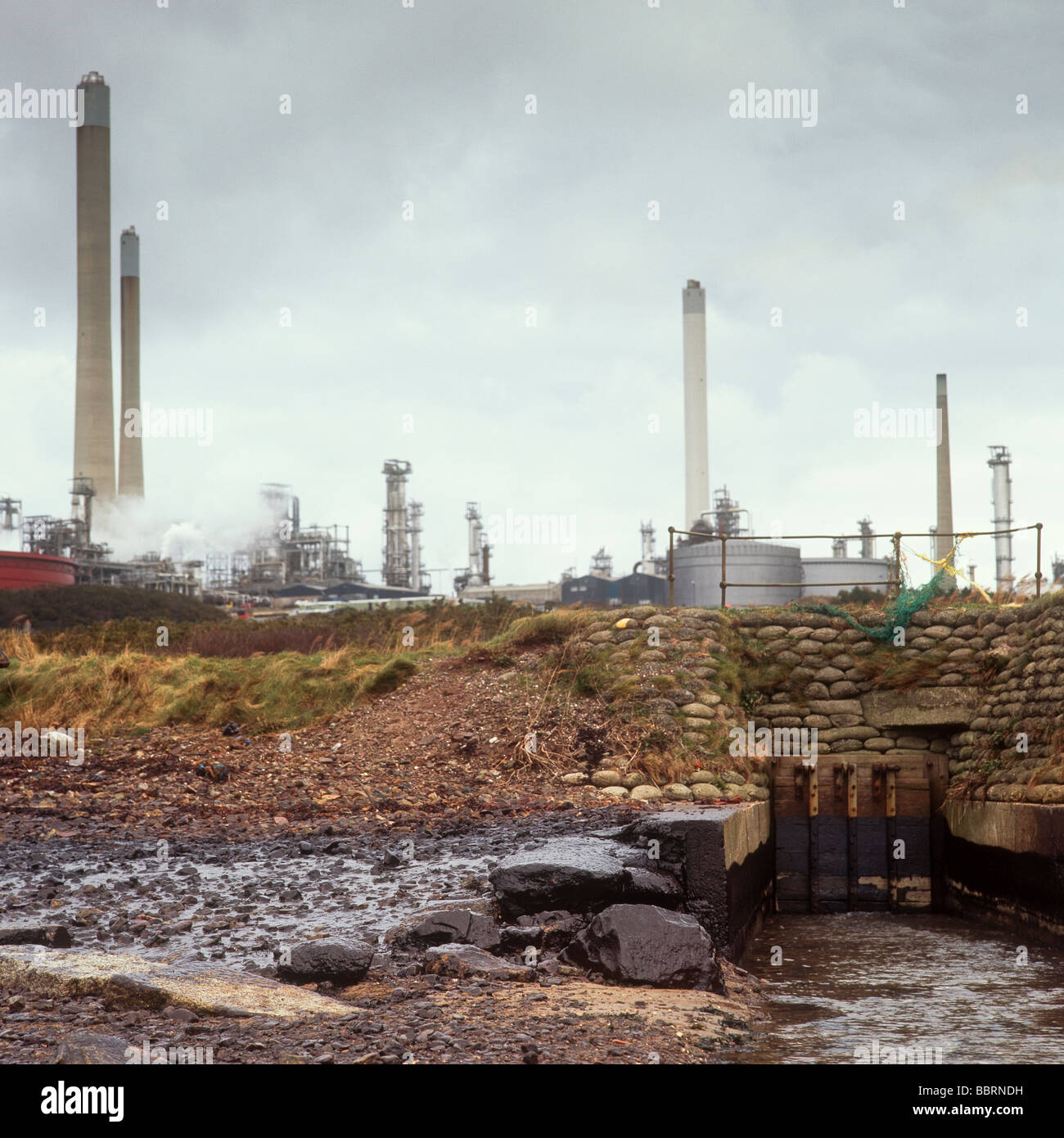 Oil refinery in Milford Haven with oil on beach foreground following ...