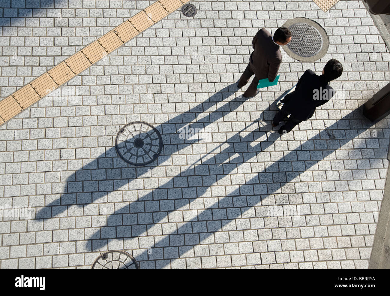 Pedestrians cast shadows on sidewalk Kumamoto city Japan Stock Photo ...