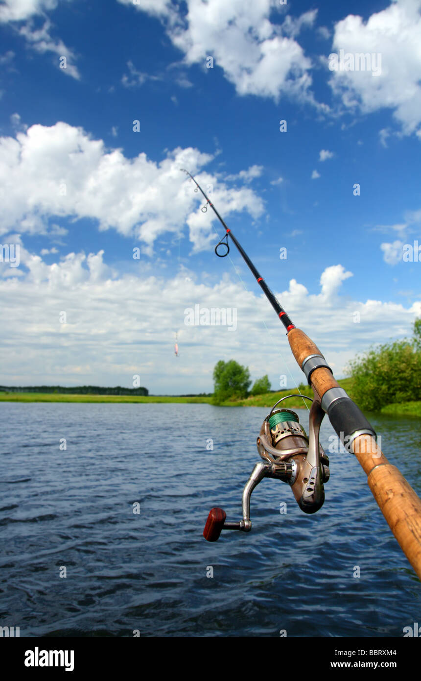 spinning with reel and summer lake Stock Photo - Alamy
