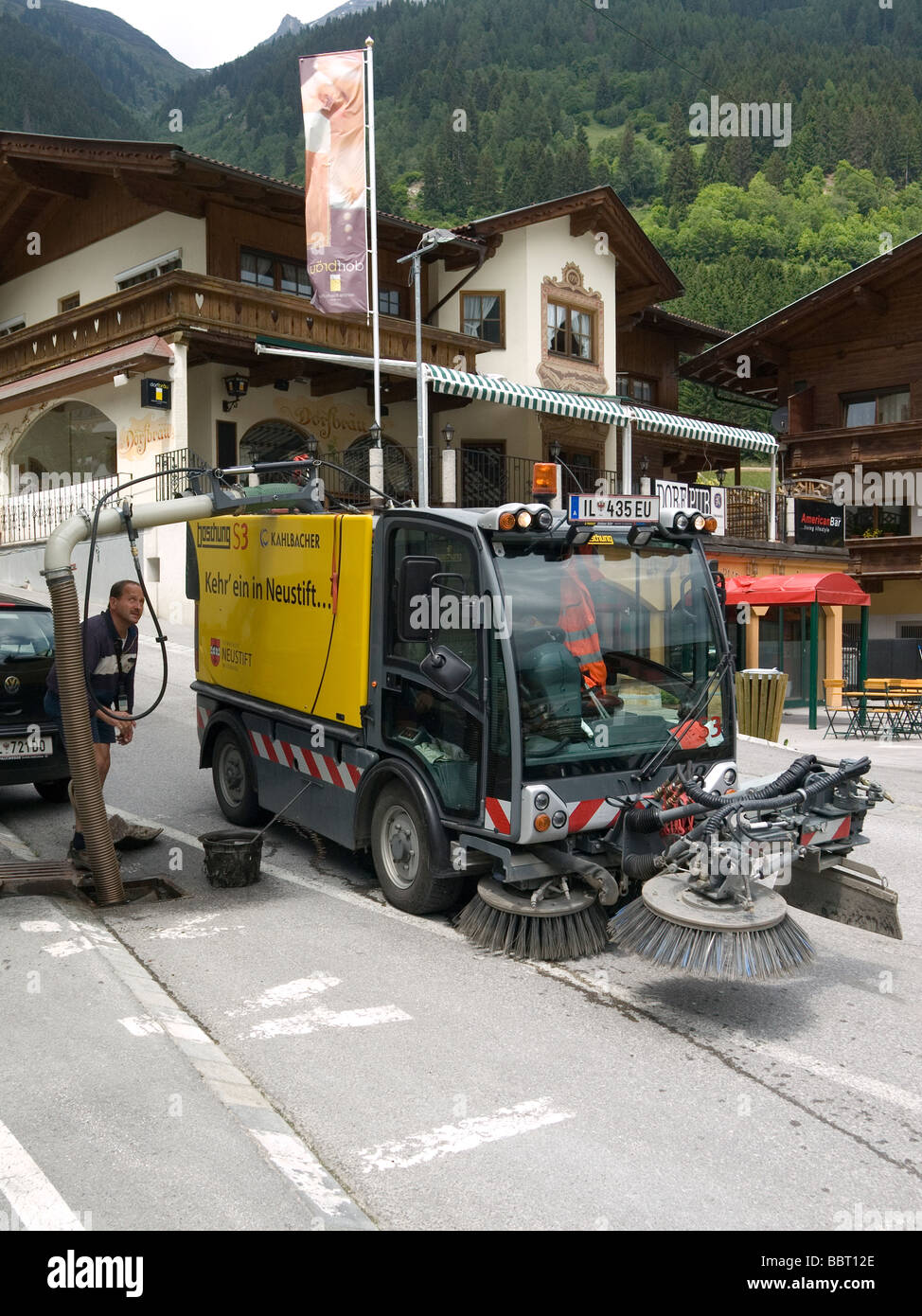 Local authority workman with a cleaning vehicle using an interceptor to ...