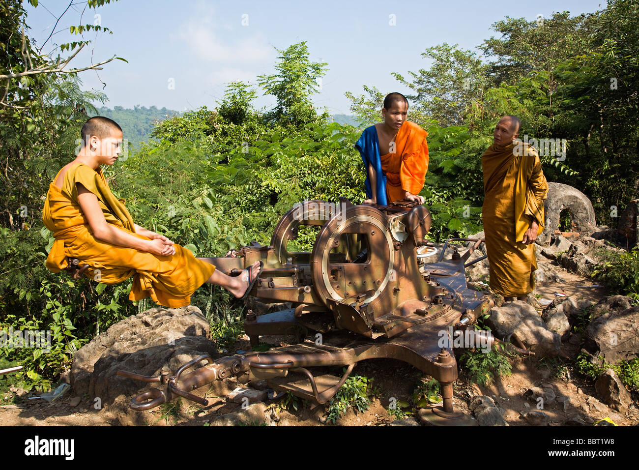 Monks playing with an old cannon on top of Phu Si hill 2007 Stock Photo ...