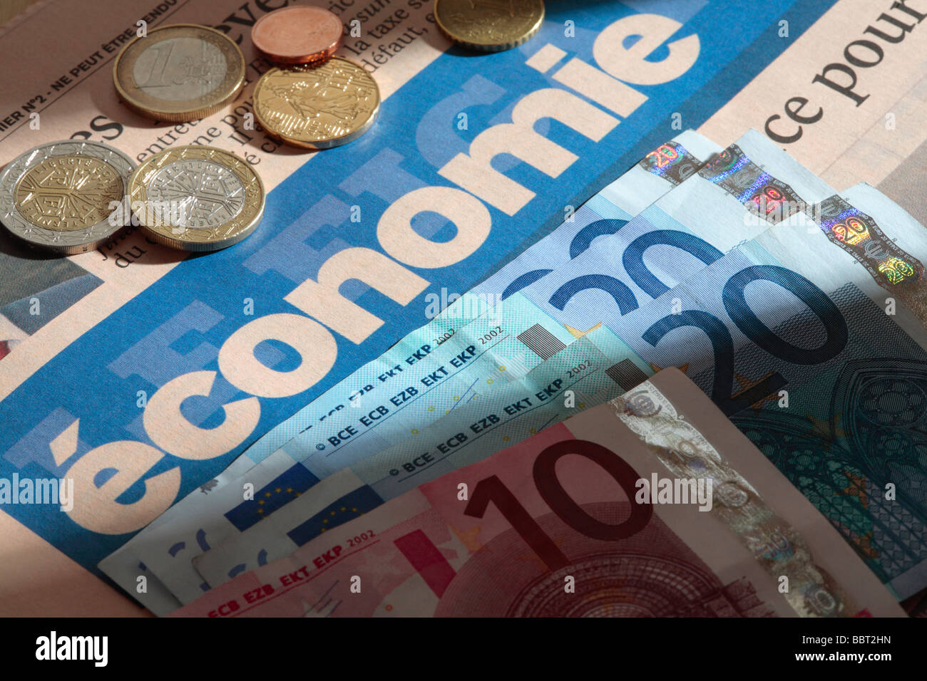 Euro Notes and Coins with économie section of a French newspaper Stock ...