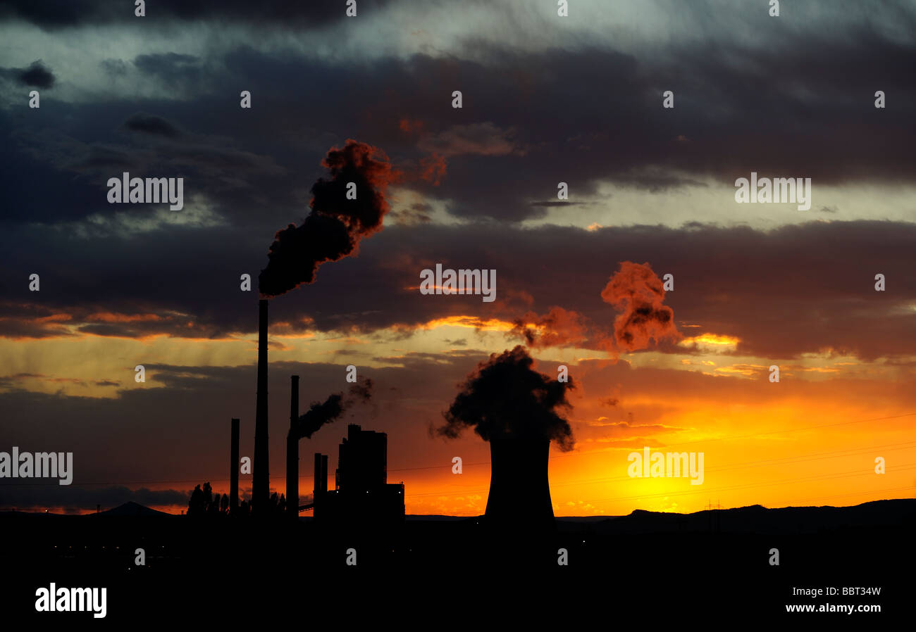 steaming coal-fired power plant at dramatic sunset, cooling towers ...