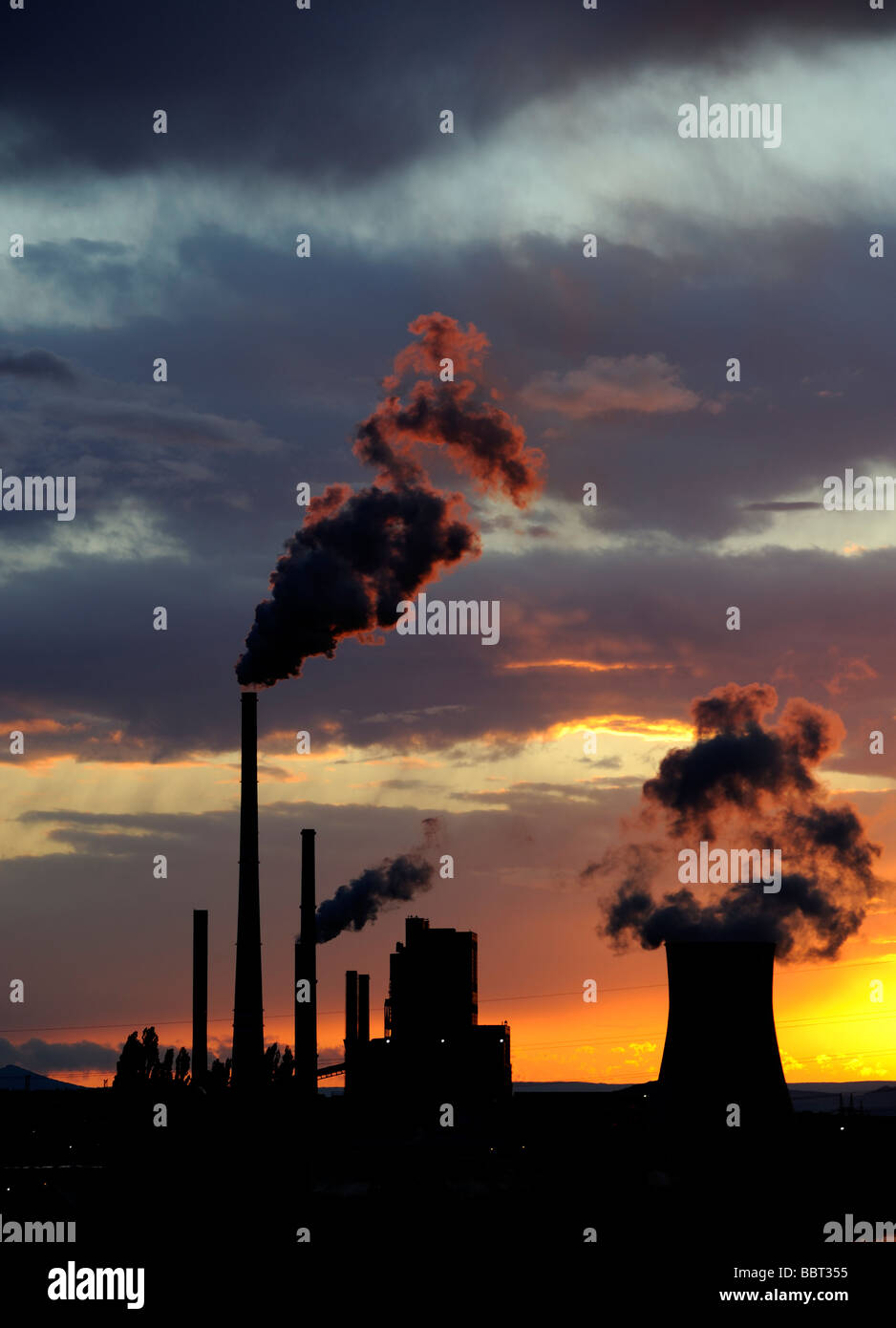 steaming coal-fired power plant at dramatic sunset, cooling towers ...