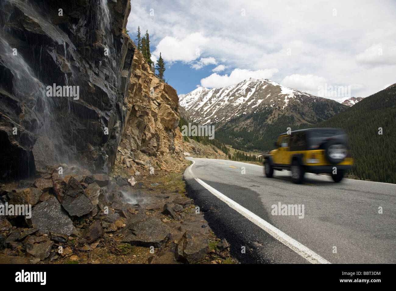 Melting snow creates a waterfall along Rt 82 near Independence Pass ...
