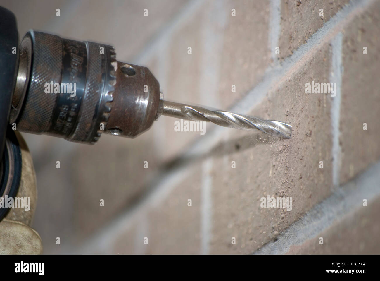 Drilling a hole in a brick wall with a masonry drill Stock Photo - Alamy