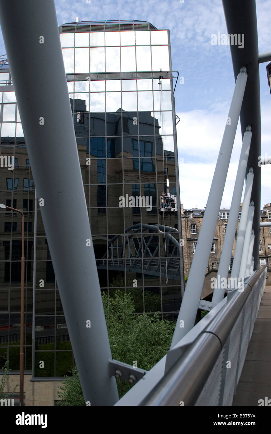Window cleaner working on a modern building from a suspended cage Stock ...