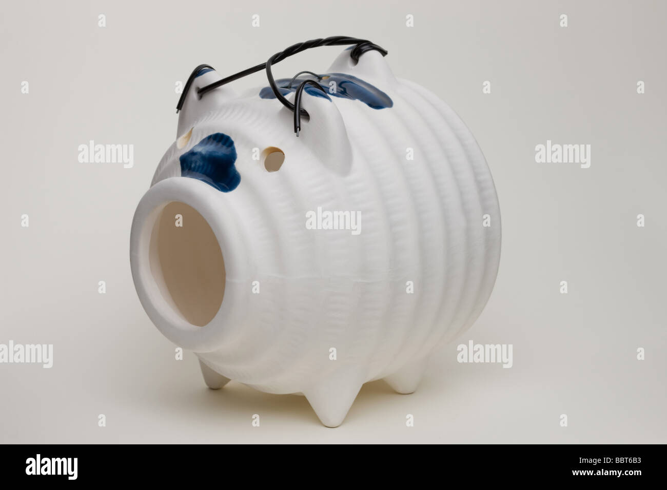 Broken piggy box tied with wire Stock Photo - Alamy