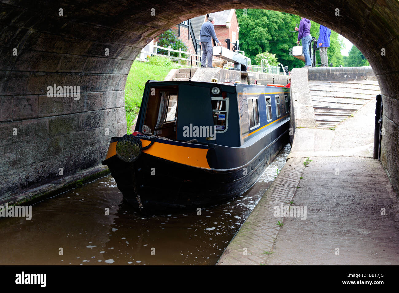 The crew of a barge negotiate their way through the gates at Tyrley ...