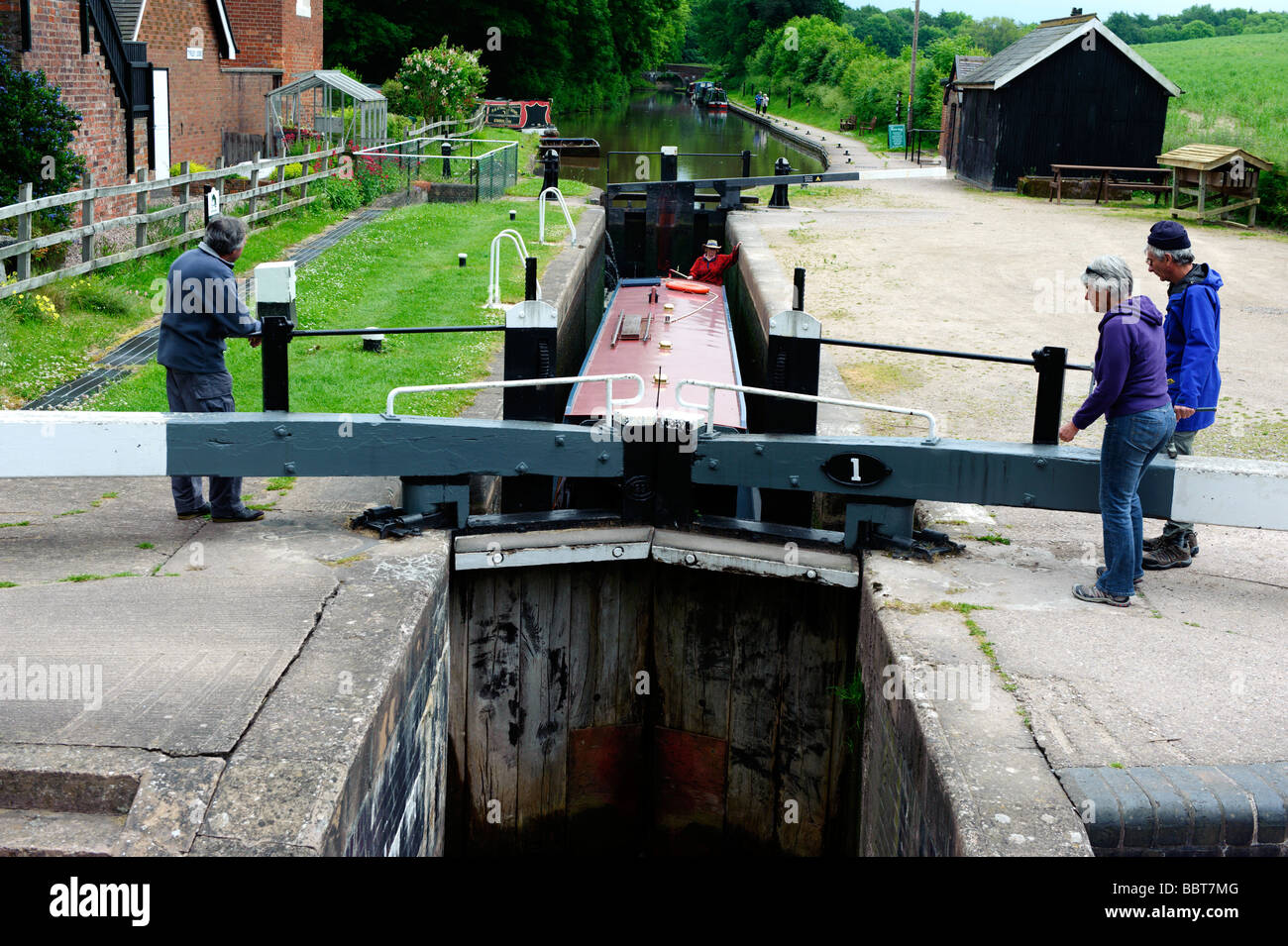 The crew of a barge negotiate their way through the gates at Tyrley ...