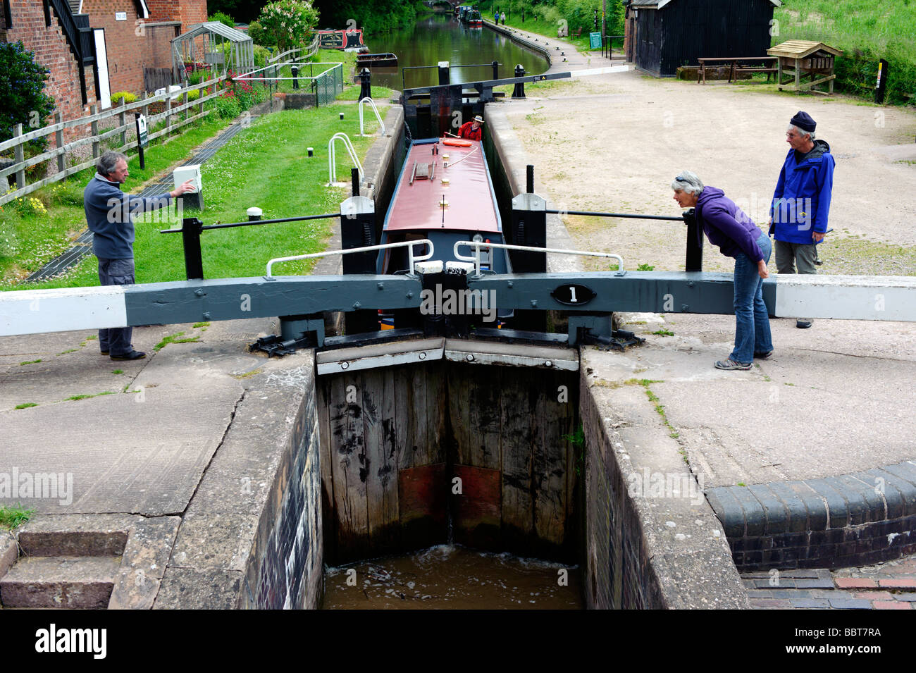 The crew of a barge negotiate their way through the gates at Tyrley ...