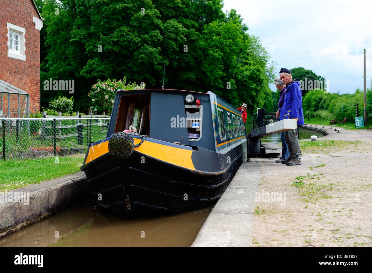 The crew of a barge negotiate their way through the gates at Tyrley ...
