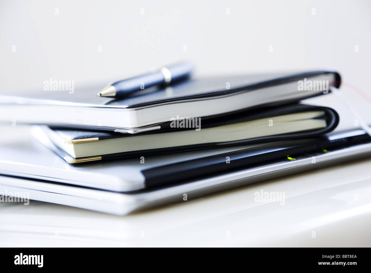 Pen lying on stacked diaries Stock Photo - Alamy