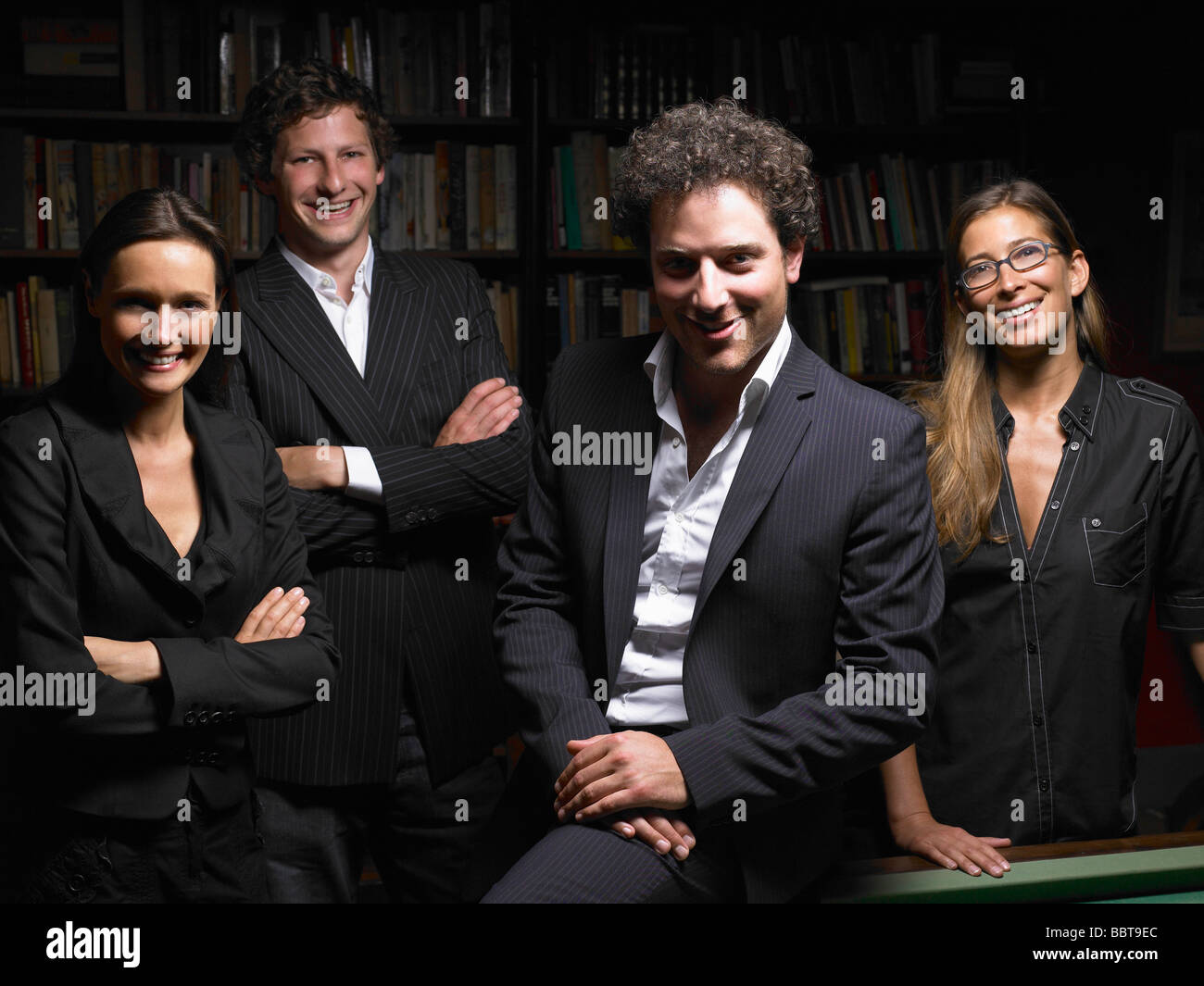 People standing in front of a bookcase Stock Photo - Alamy