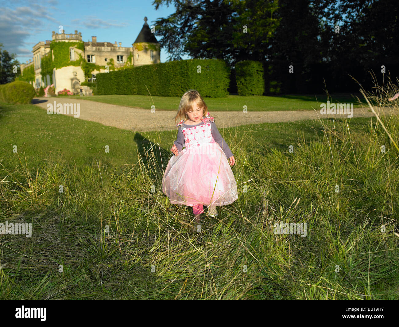 Girl with princess dress, castle behind Stock Photo - Alamy