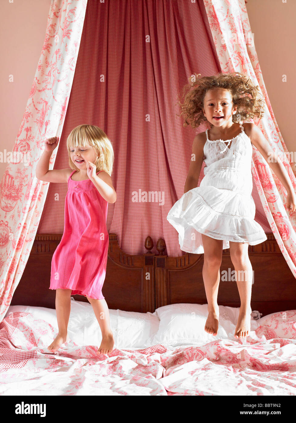 Girls jumping on a bed Stock Photo - Alamy