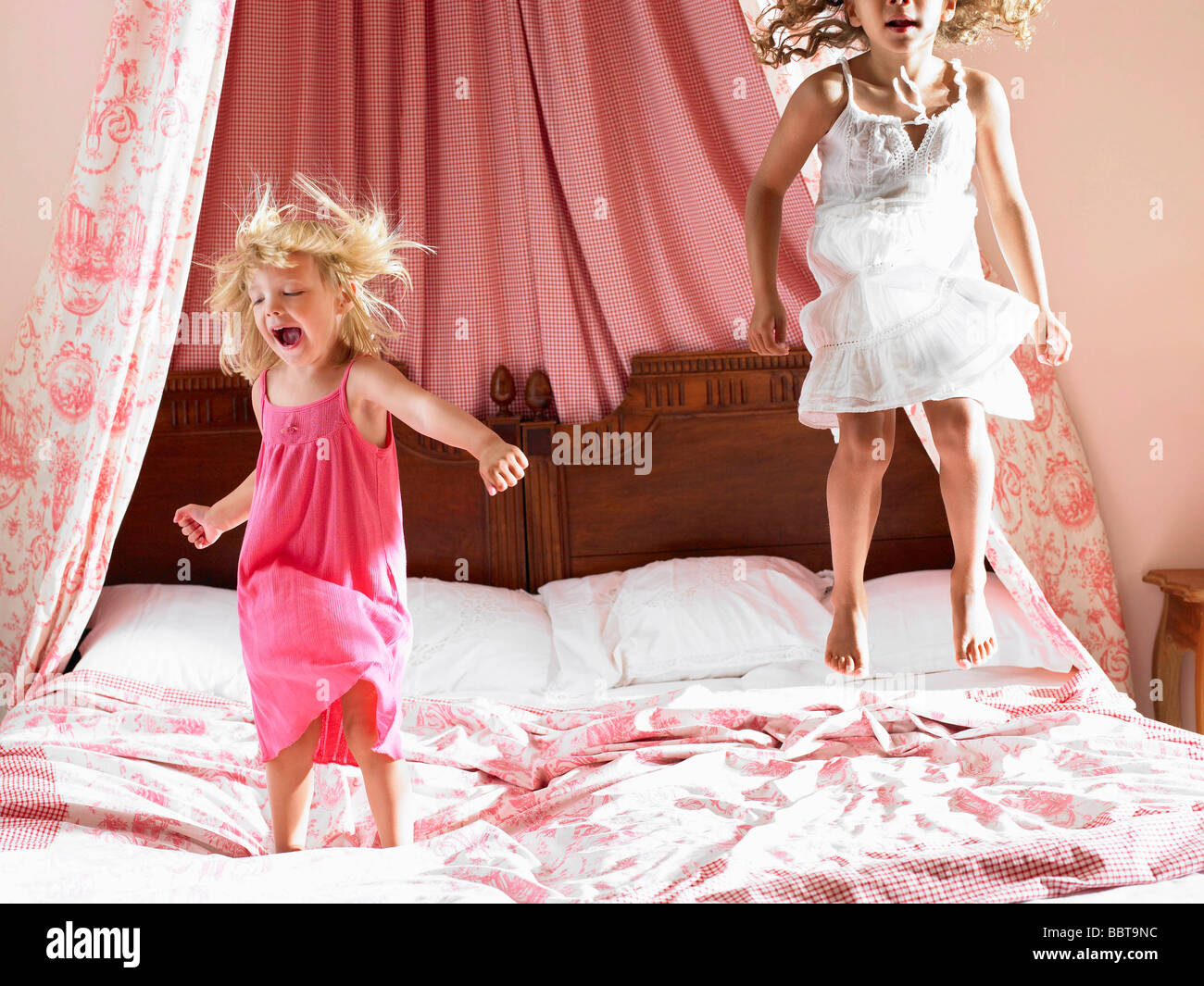 Girls jumping on a bed Stock Photo - Alamy