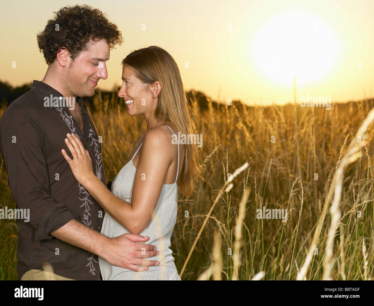 European couple hugging sunset face hi-res stock photography and images ...
