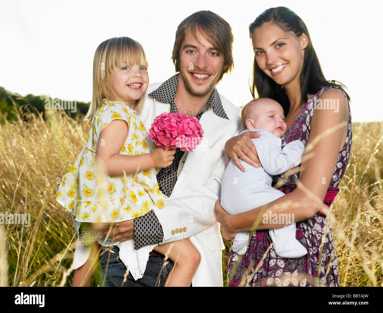 Family in a field, smiling Stock Photo - Alamy