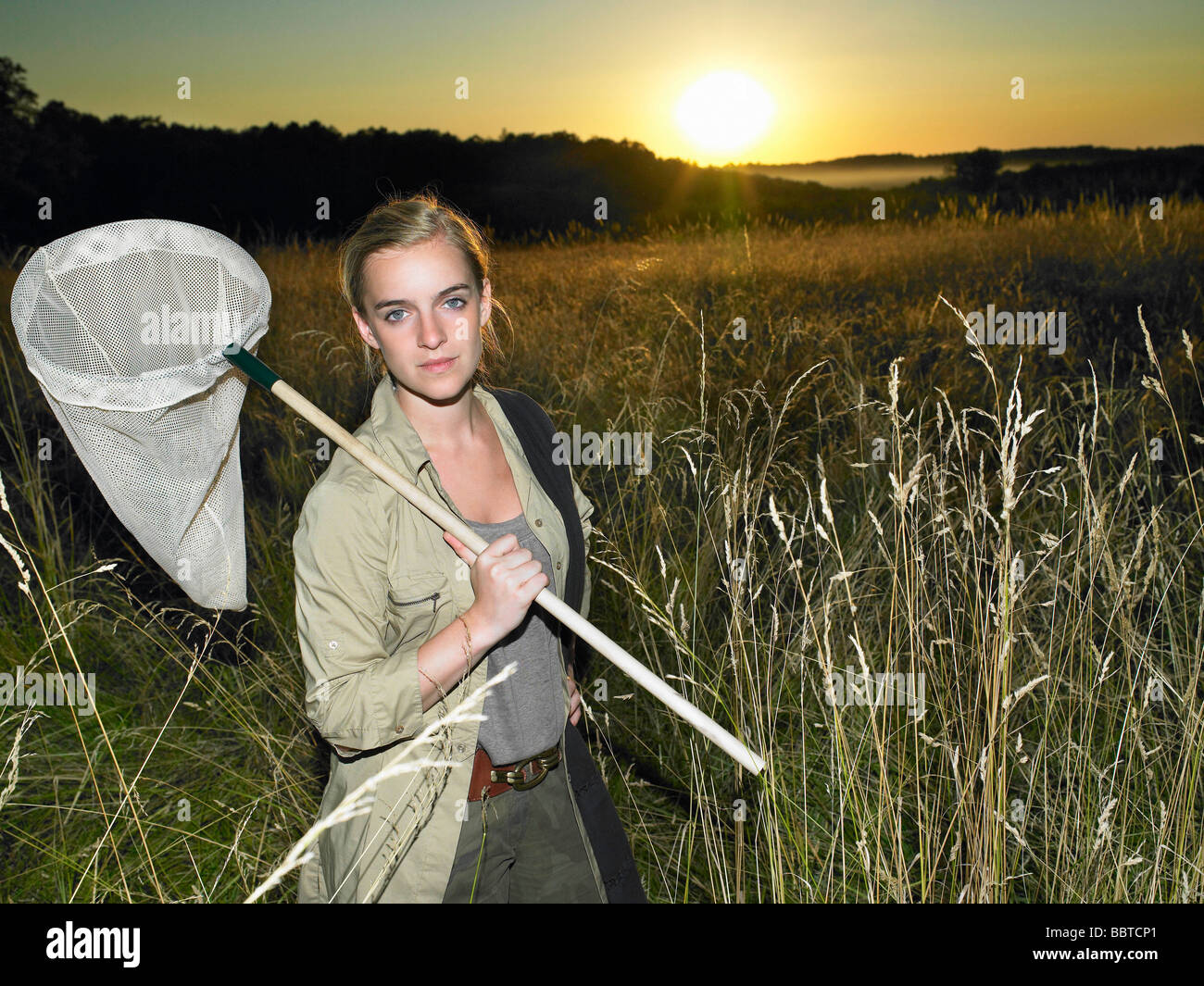 Woman with butterfly net, sunset Stock Photo - Alamy