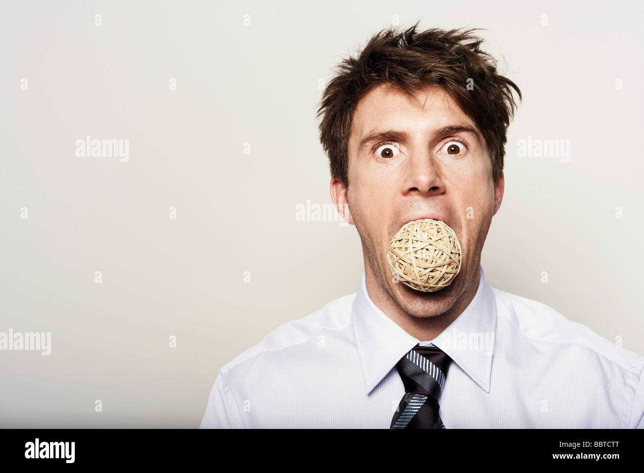 Business man with ball in mouth Stock Photo - Alamy