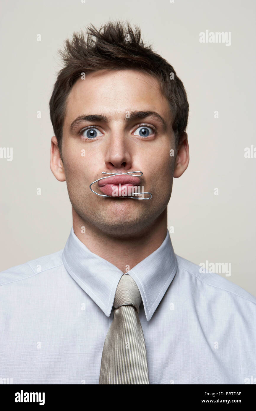 Business man with paper clip around lips Stock Photo - Alamy