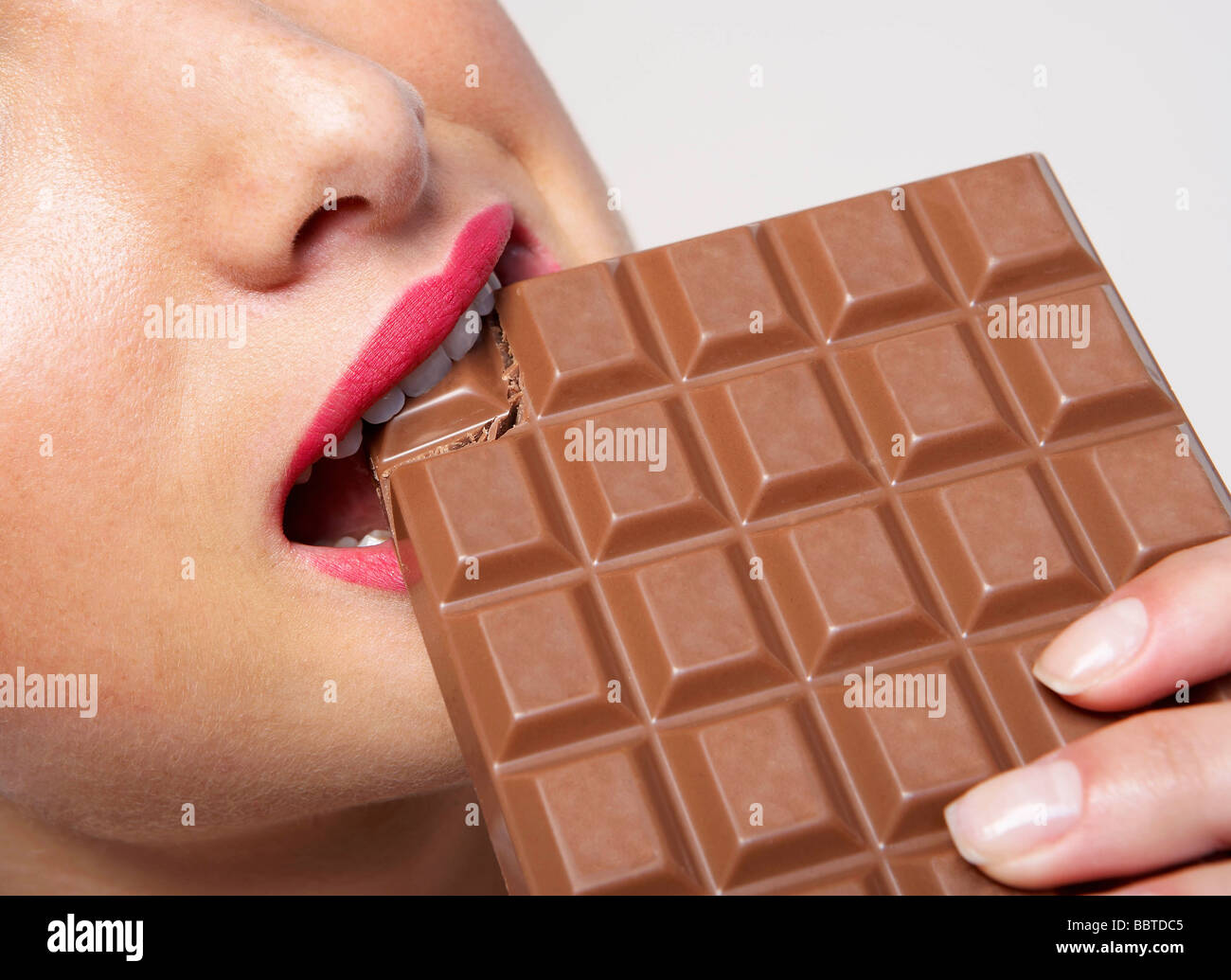 Woman biting huge bar of chocolate Stock Photo - Alamy