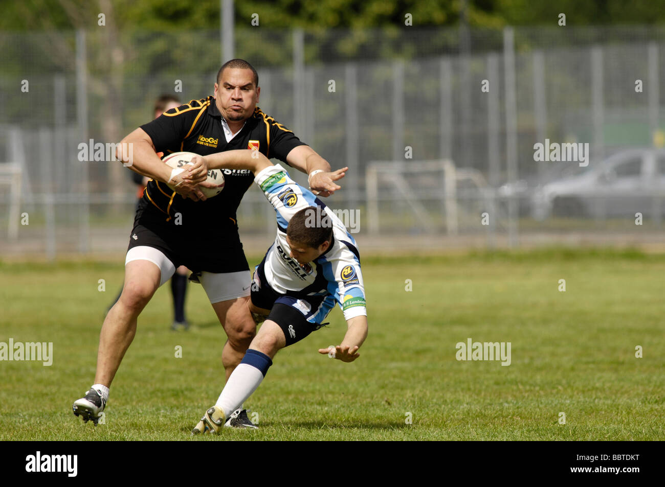rugby player forces his way past a smaller oponent Stock Photo - Alamy