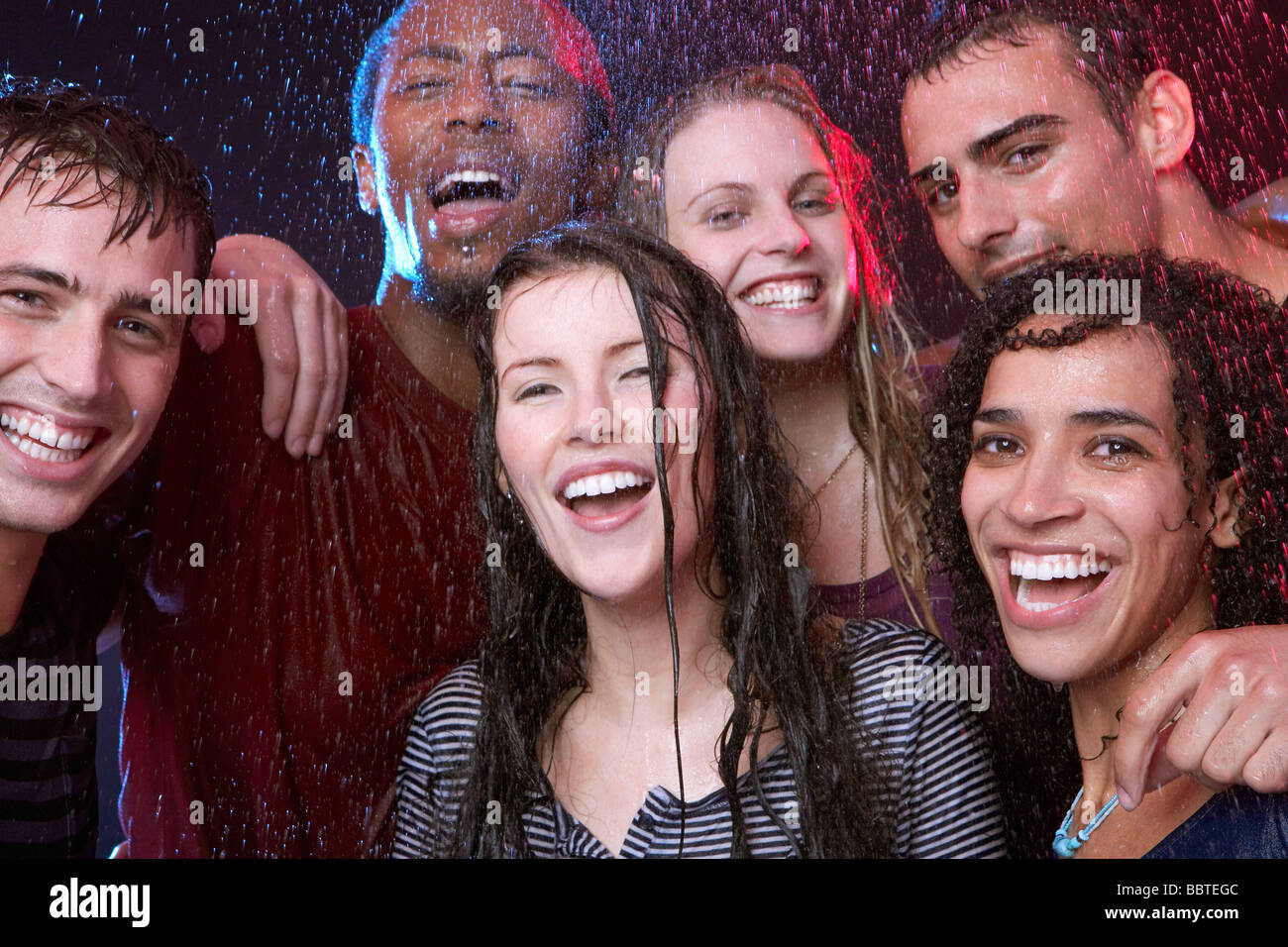 Group of young friends in the rain Stock Photo - Alamy