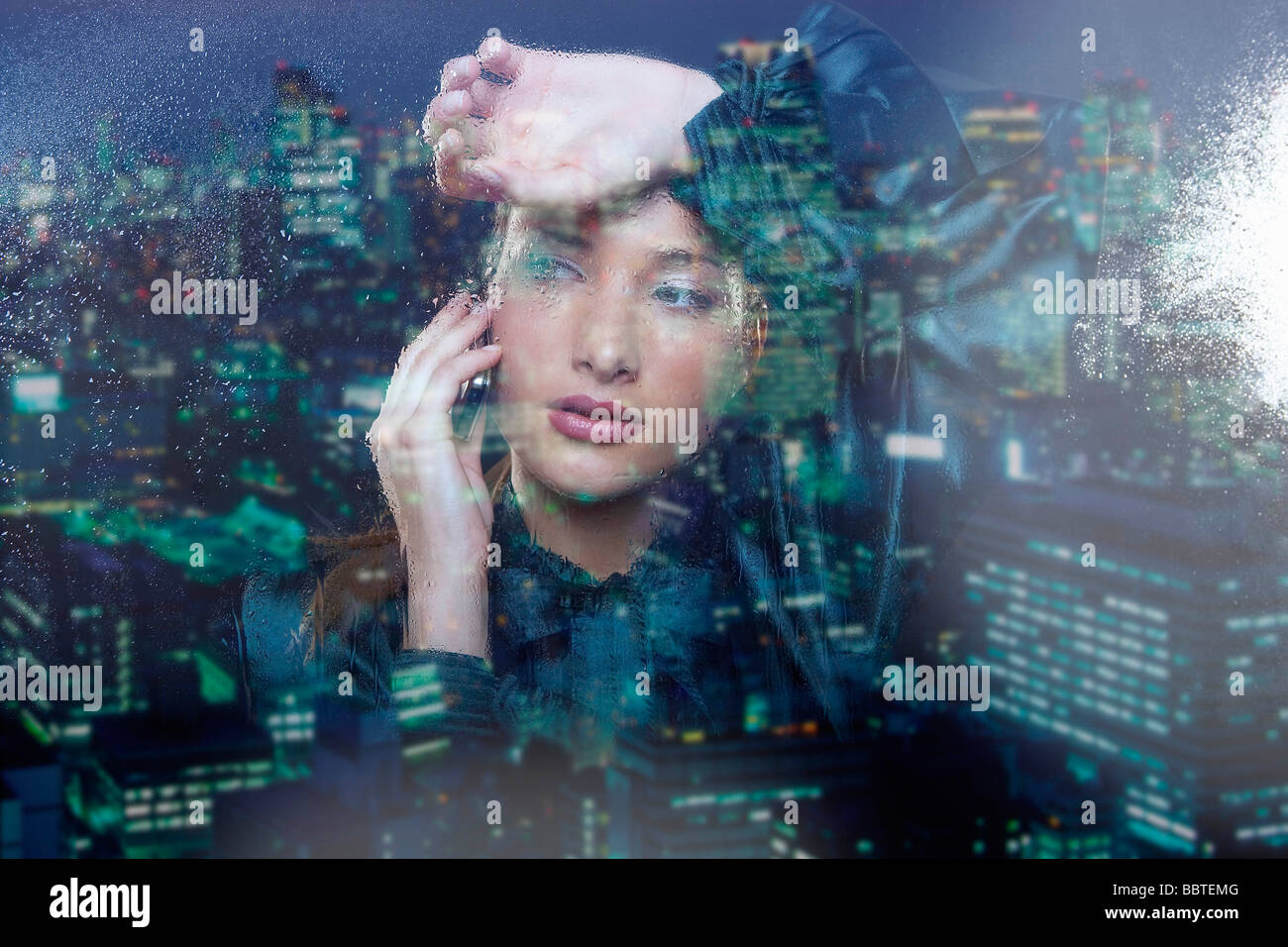 Woman at window with city reflections Stock Photo - Alamy