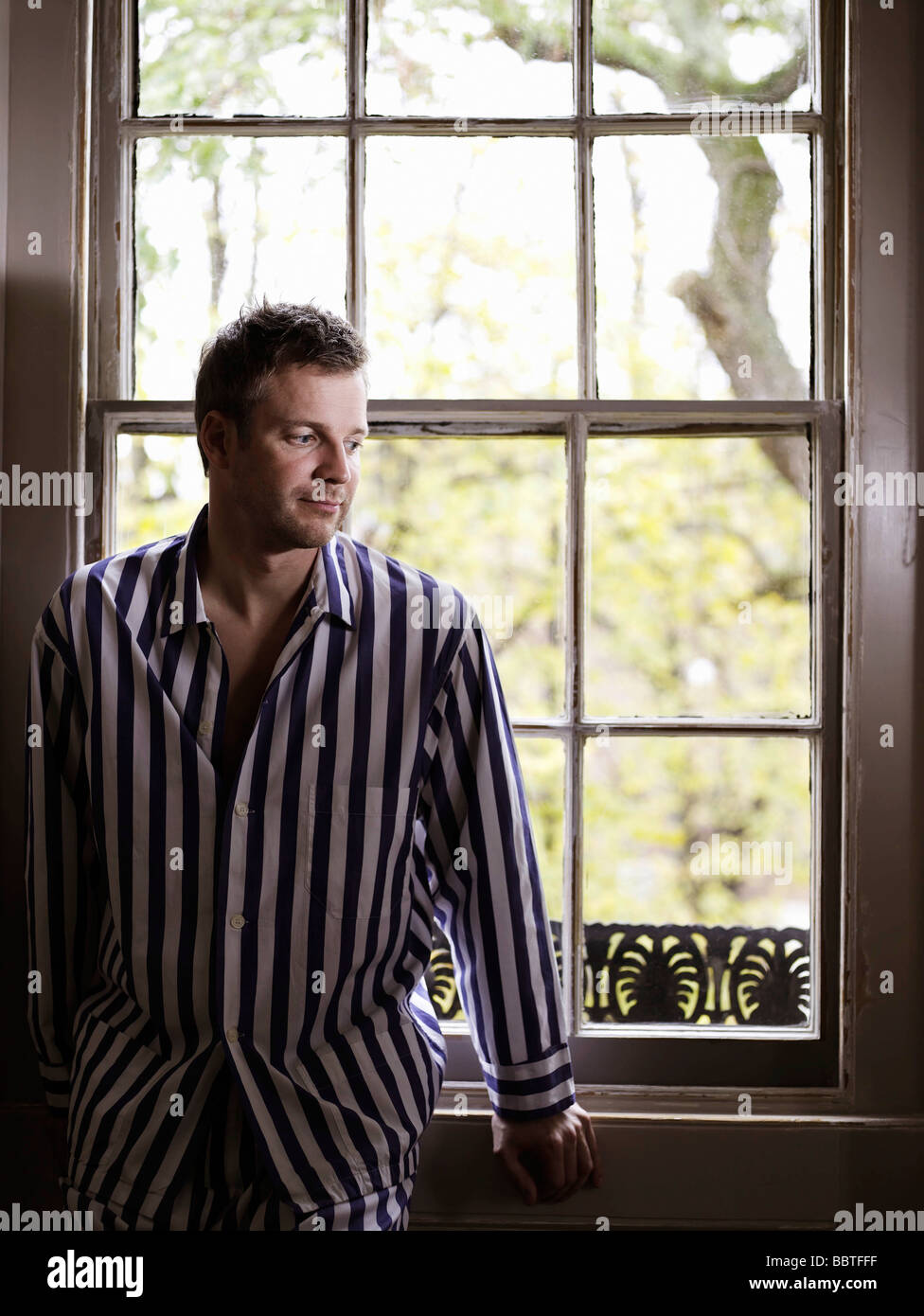 Man sitting window in pajamas hi-res stock photography and images - Alamy