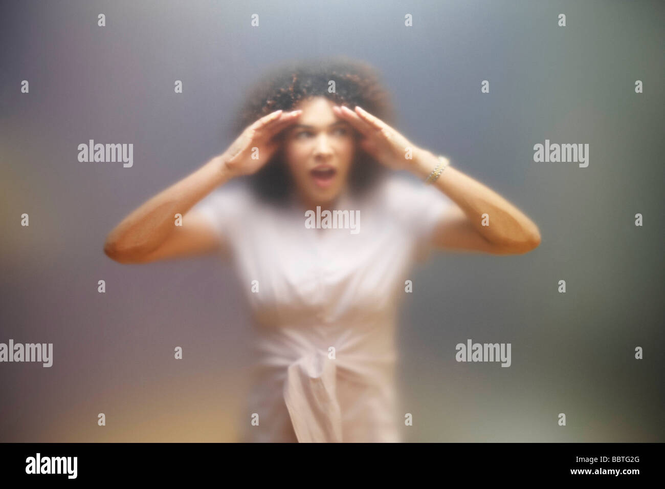 Woman peering through frosted screen Stock Photo - Alamy