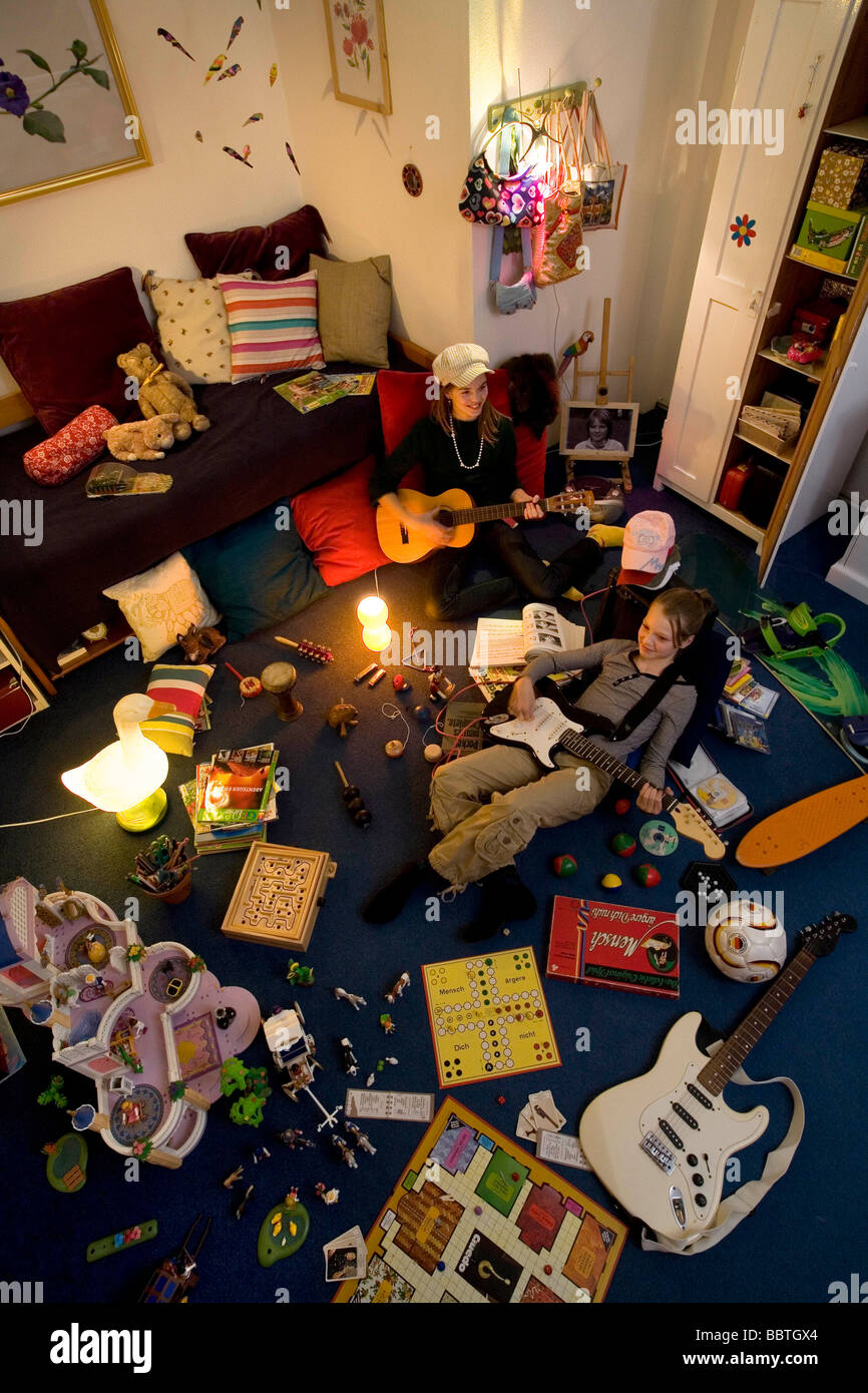 Two girls play guitar in crowded room Stock Photo - Alamy