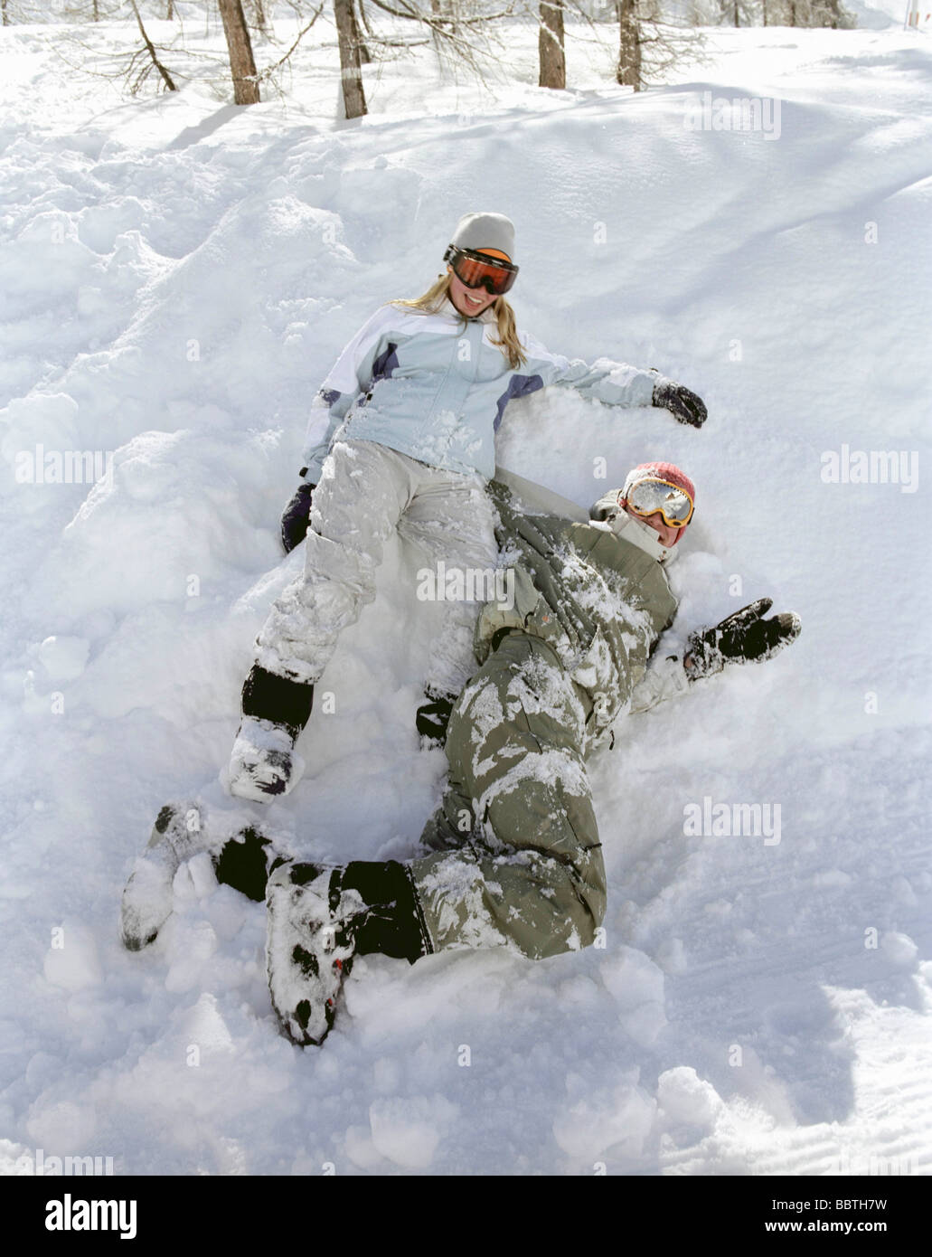 Couple sitting in snow, laughing Stock Photo - Alamy