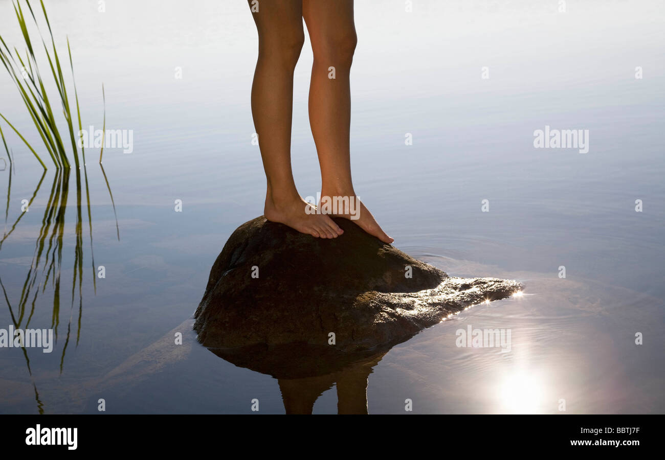 Woman standing on rock Stock Photo - Alamy