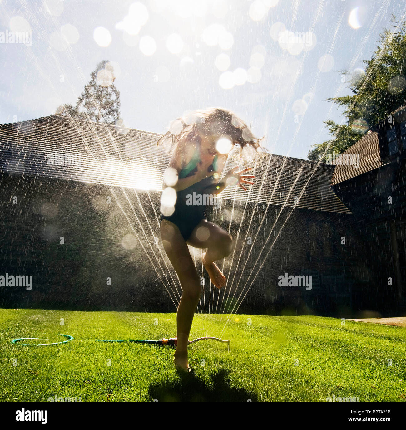 Girl Running Through Sprinkler Stock Photos & Girl Running Through Sprinkler Stock Images - Alamy