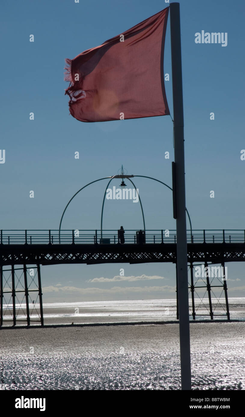 A red flag flies on the beach at Southport, Merseyside, near the pier ...