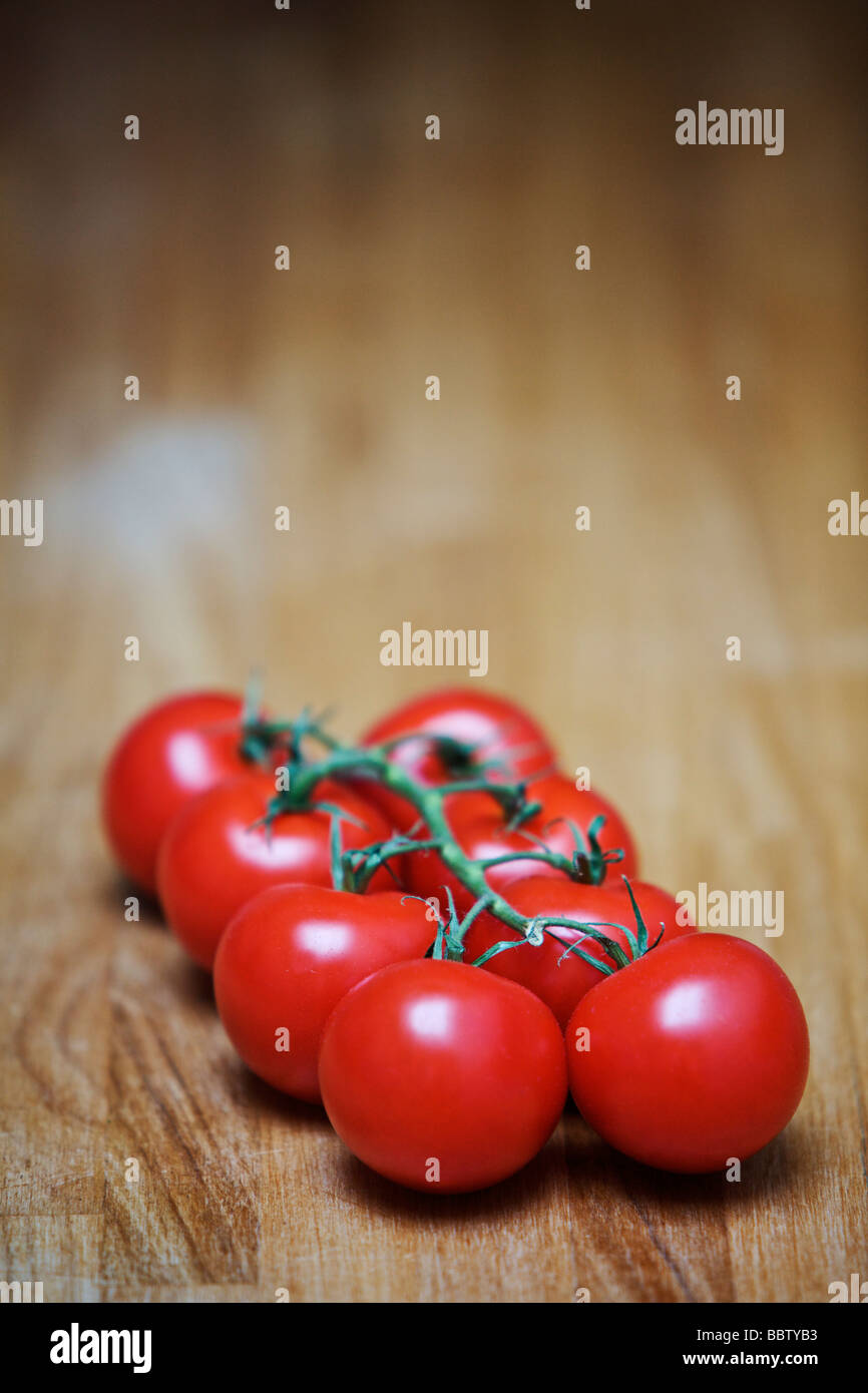 Eight on the vine tomatoes on wooden surface Stock Photo - Alamy