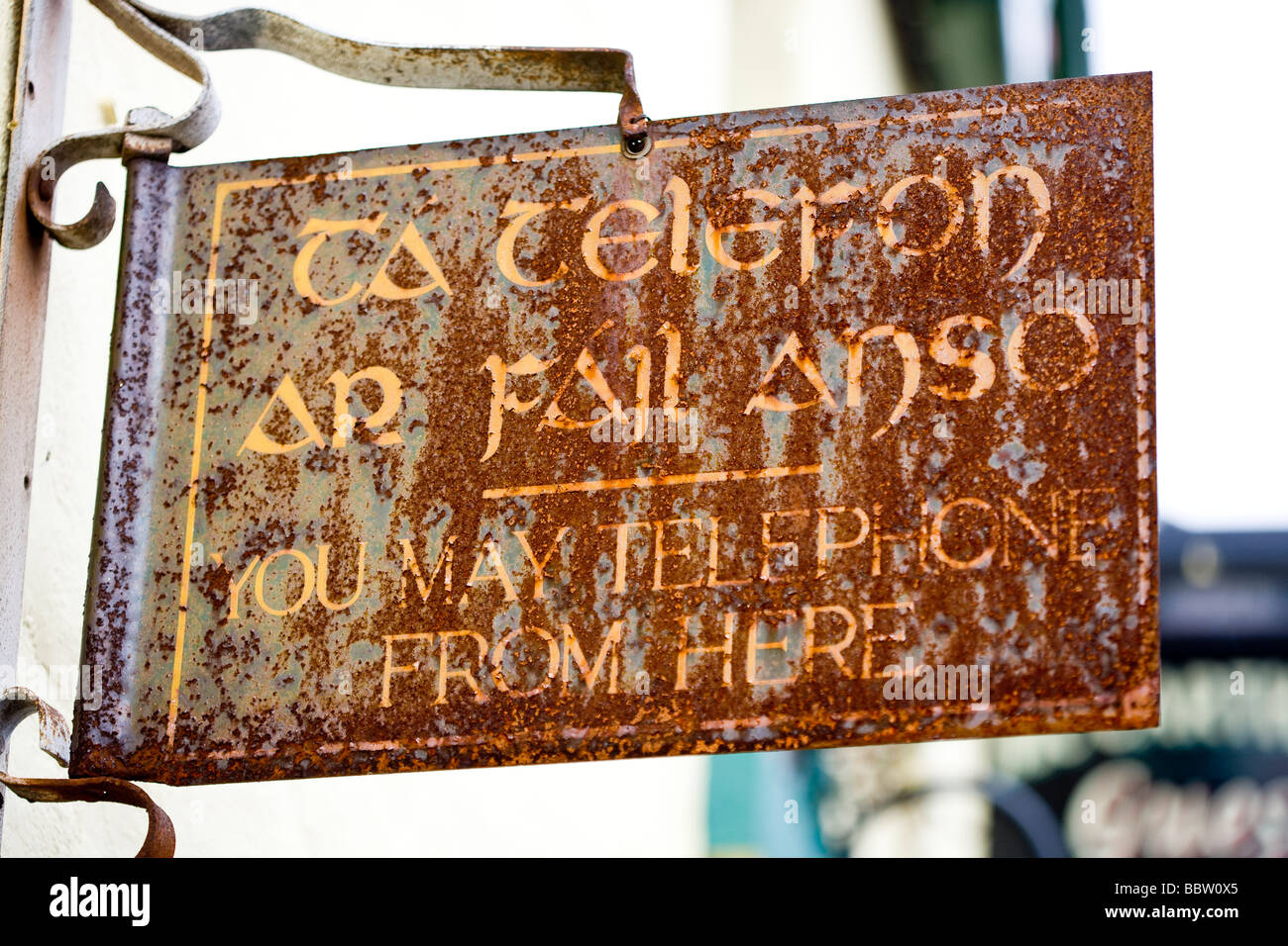 Rusty Bilingual Public Telephone Sign on the side of a shop. An old ...