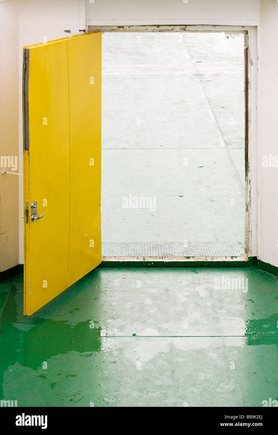 yellow open door in white wall on green floor Stock Photo - Alamy