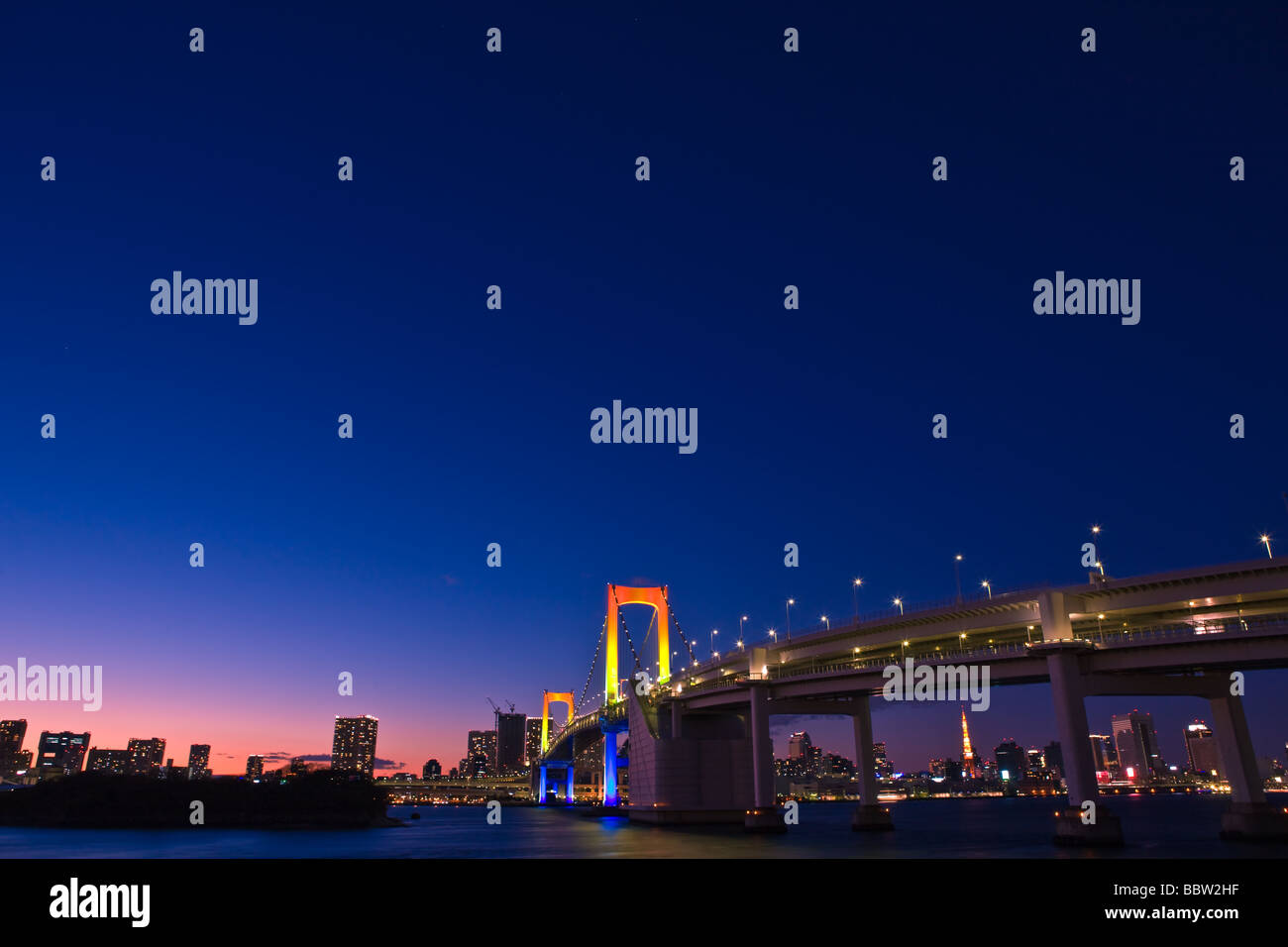 Rainbow bridge with buildings and illuminated lights in nighttime Stock ...