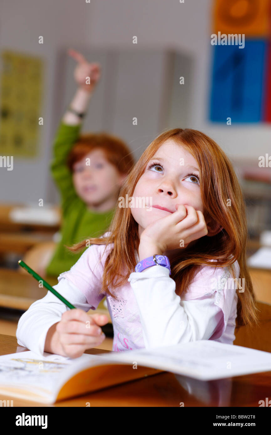 Children in a classroom in primary school, girl looking clever, cunning ...