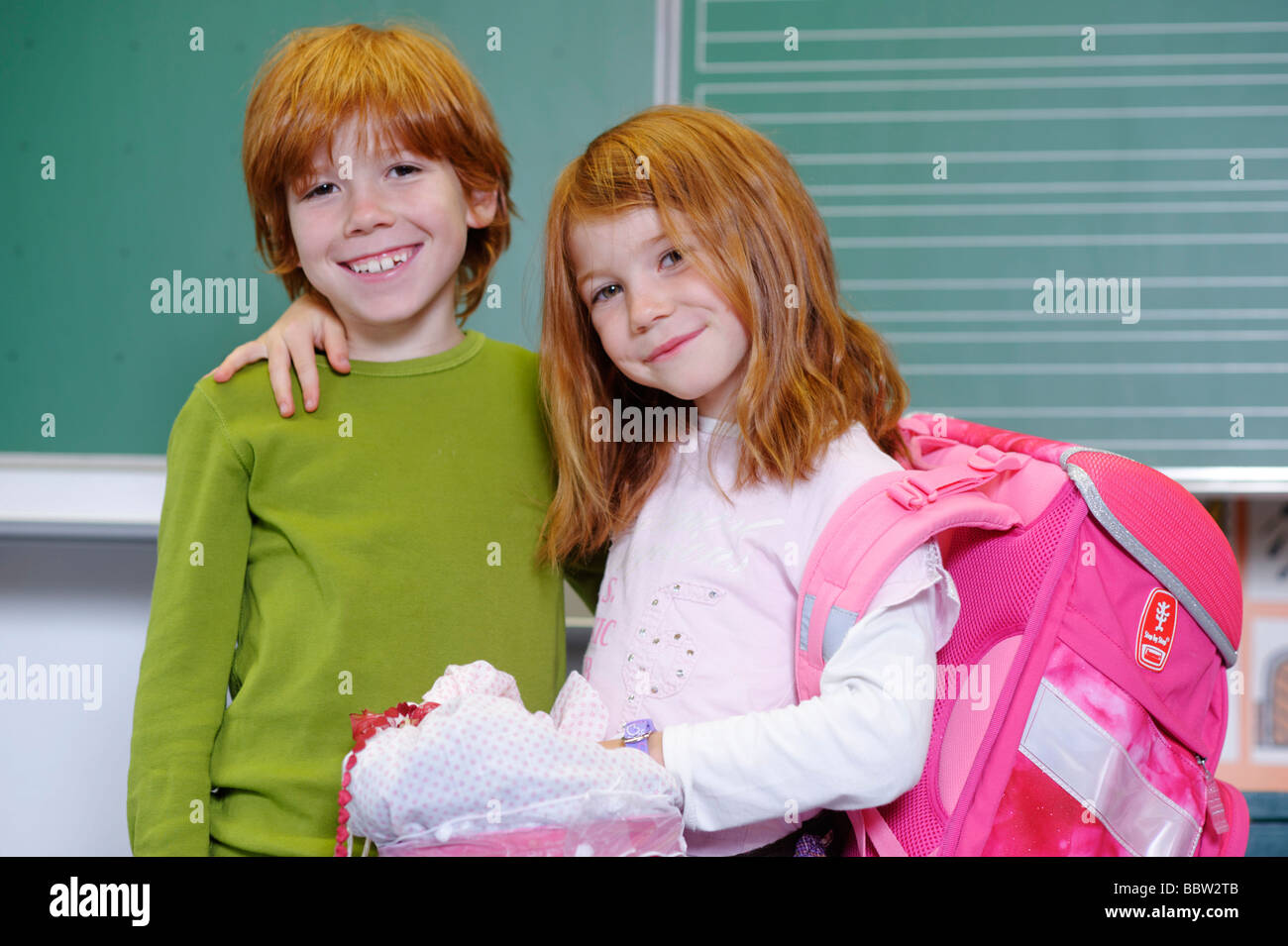 Two children in primary school, friends or siblings in a classroom ...