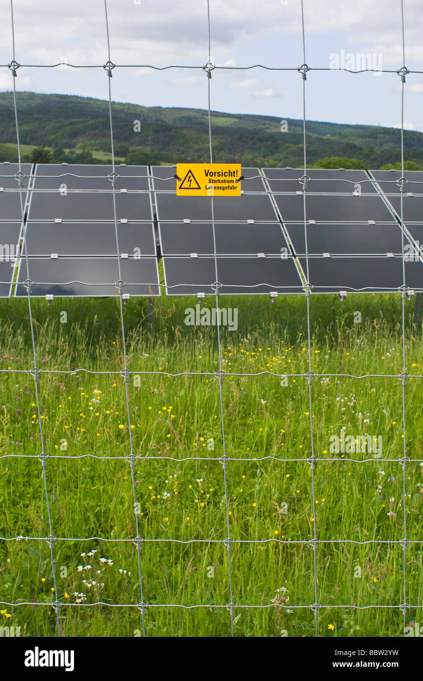 Photovoltaic power plant, several modules behind safety fence, warning ...