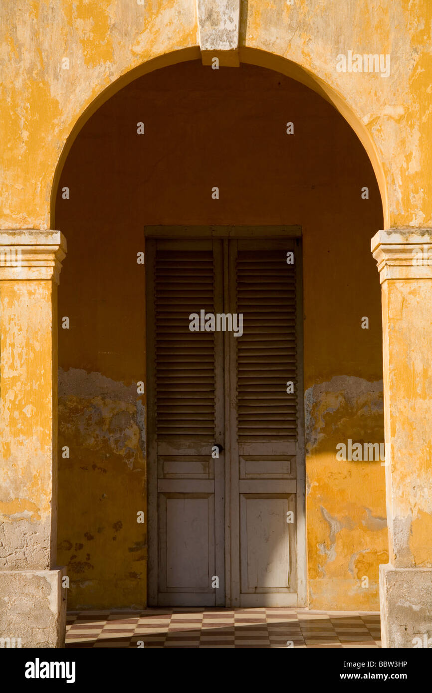 Weathered yellow french-colonial archway and door in Phnom Penh ...