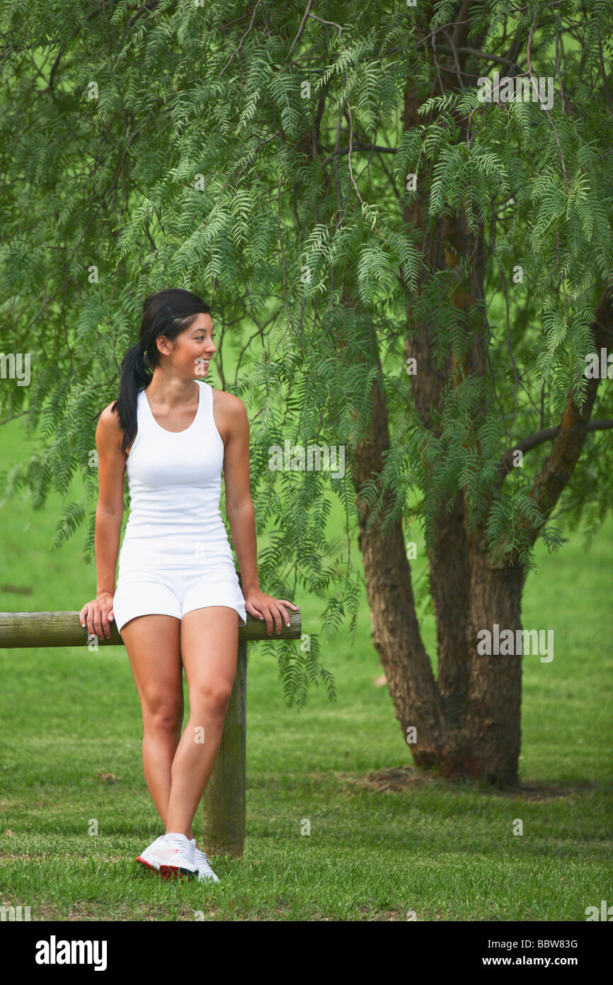 Young Woman sitting on log near tree Stock Photo - Alamy