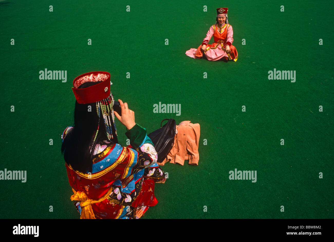 Costumed tourists pose for pictures in the Splendid China model village ...